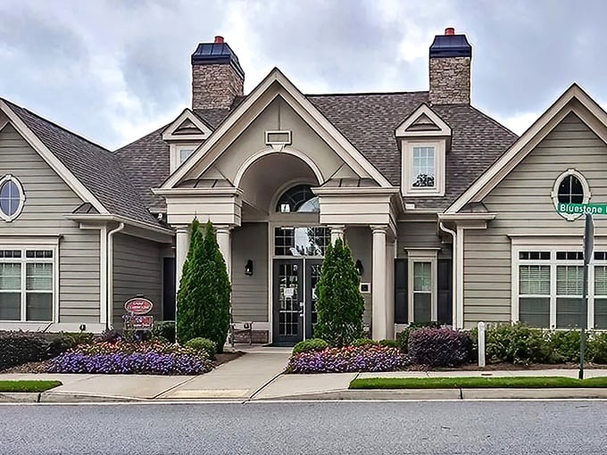 The clubhouse entrance says "welcome home" with its grand columns and manicured landscaping. Southern hospitality in architectural form.