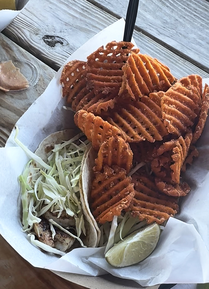 Waffle fries standing guard around a fish taco like crispy sentinels&mdash;this is what happens when the ocean and potato patch collaborate brilliantly.