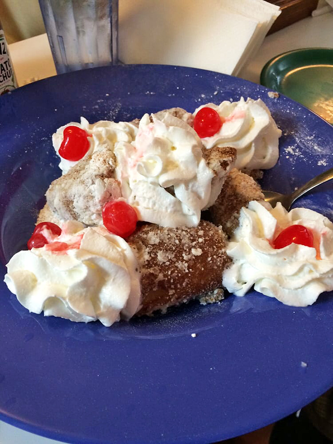 These apple fritters with whipped cream and cherries aren't just dessert, they're an event. Calories? Worth every single one.