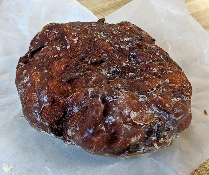 This apple fritter isn't just a donut &ndash; it's an architectural marvel of caramelized edges, apple chunks, and glaze that would make Frank Lloyd Wright weep with joy.