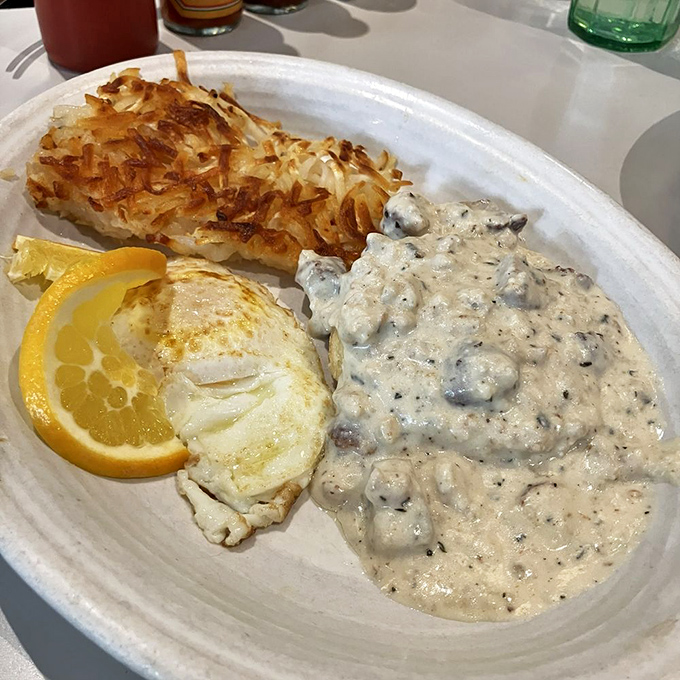Behold the star attraction: perfectly peppered gravy studded with sausage chunks, golden hash browns, and an egg that's ready for its close-up.