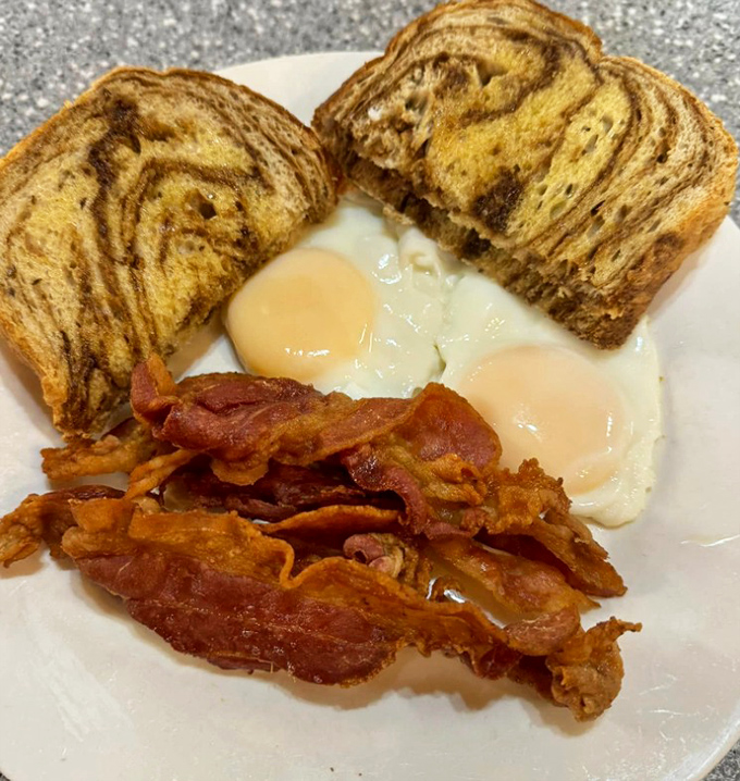 Behold the holy trinity of breakfast: perfectly cooked eggs, marble rye toast, and bacon that would make even vegetarians question their life choices.