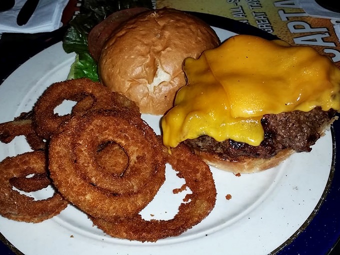 Behold the masterpiece: a perfectly melted cheese blanket hugging that half-pound patty. Those onion rings aren't just sides&mdash;they're supporting actors deserving awards.