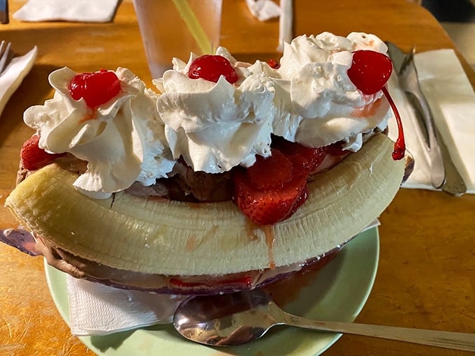 This banana split isn't just dessert; it's architecture, sculpture, and therapy all served in a boat that could sail you to cloud nine.