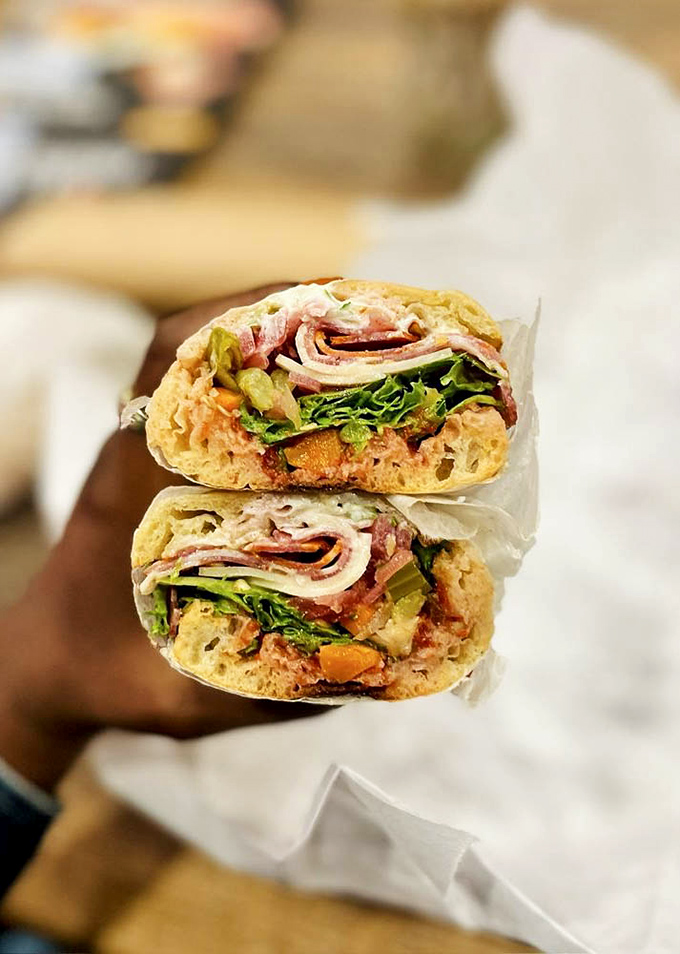 Cross-section perfection! This sandwich doesn't just satisfy hunger—it creates memories with layers of cured meats, fresh vegetables, and that perfect bread-to-filling ratio.