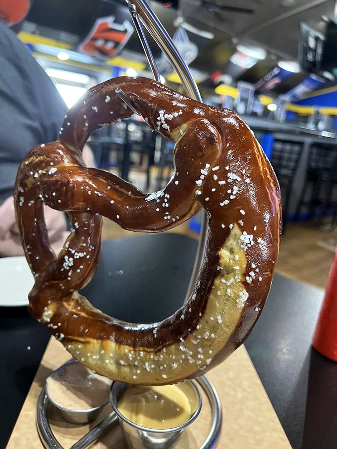 Behold the legendary Bavarian pretzel in all its glory &ndash; hanging majestically like edible artwork, with two dipping companions awaiting your decision.