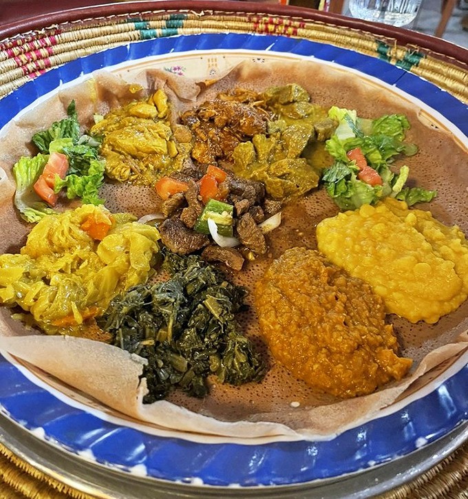 Behold the Ethiopian combination platter&mdash;a colorful canvas of flavors atop injera bread. It's like edible art where every brushstroke is deliciously spiced.