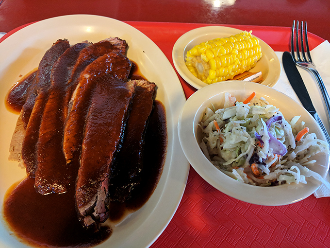 Brisket so tender it practically surrenders to your fork, accompanied by coleslaw and corn that know their supporting roles perfectly.