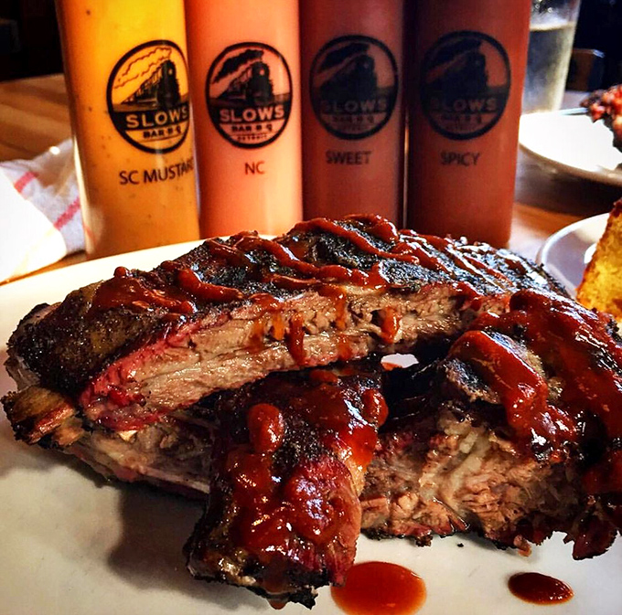 Behold, the carnivore's dream—ribs so tender they practically surrender to your fork while sauce bottles stand guard like flavor sentinels.