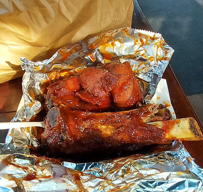 Behold the star of the show: a beef rib that makes Fred Flintstone's car-tipping portion look reasonable, glistening with that perfect lacquered bark.
