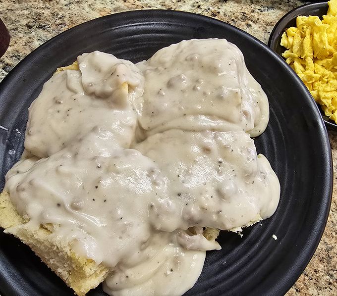 Biscuits drowning in creamy, peppery sausage gravy – a Southern breakfast tradition that's worth every napkin you'll need afterward.