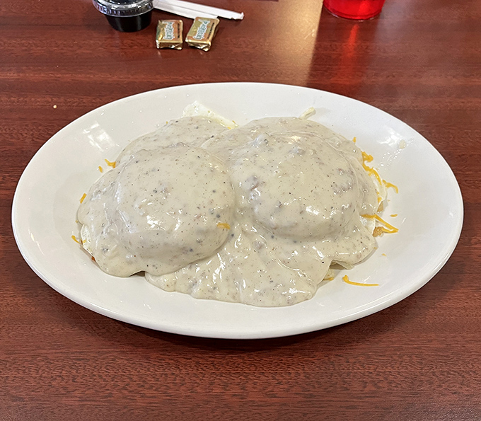 Behold the star attraction: two cloud-like biscuits swimming in a sea of peppery sausage gravy. Breakfast nirvana on a simple white plate.