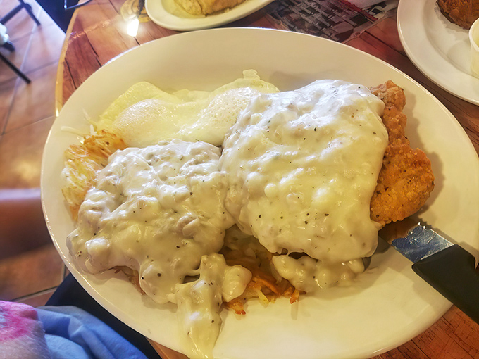Behold the holy grail of breakfast: fluffy biscuits drowning in creamy sausage gravy that defies gravity and logic.
