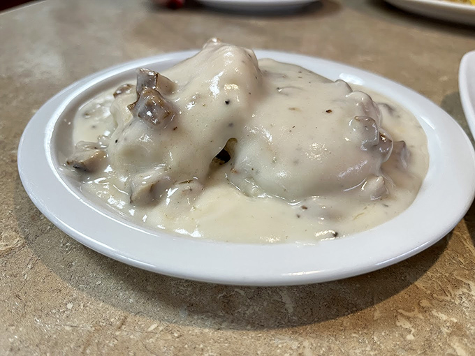 Behold the holy grail of comfort food: biscuits smothered in sausage gravy so creamy it should require a warning label for inducing spontaneous happiness.