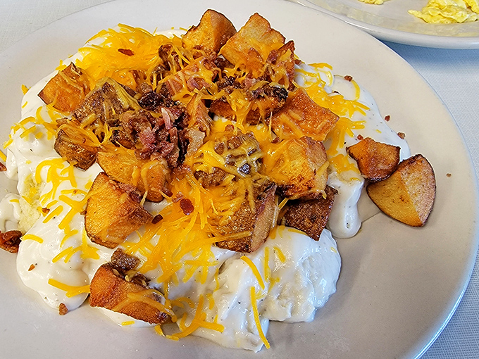 This isn't just biscuits and gravy&mdash;it's a masterpiece of comfort food architecture with potatoes, cheese, and bacon forming a delicious skyline.