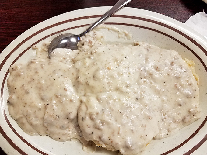 Behold the holy grail of diner breakfasts: biscuits and gravy so generously portioned they practically cascade off the plate like a savory waterfall.
