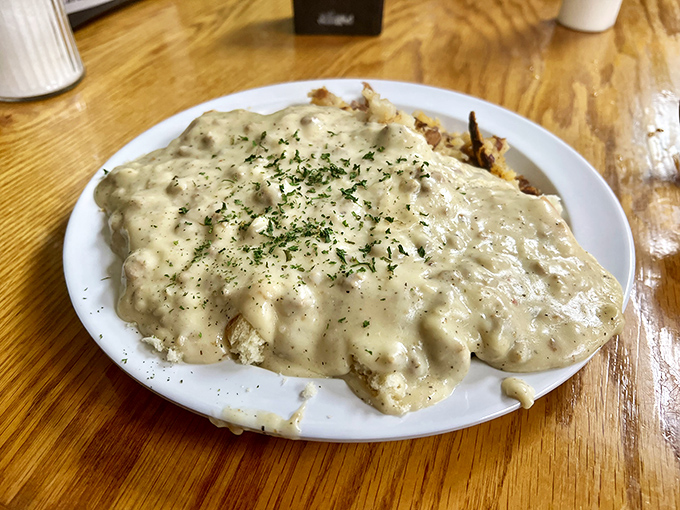 Behold the star attraction: biscuits and gravy that doesn't so much sit on the plate as command it, with creamy sausage gravy cascading over every delicious inch.
