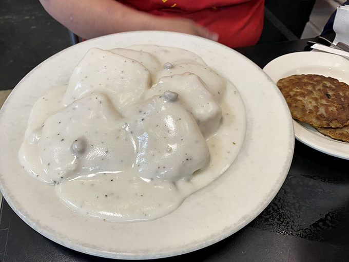 Behold the star attraction: biscuits drowning in creamy, peppery gravy. This plate has launched a thousand food pilgrimages and zero regrets.