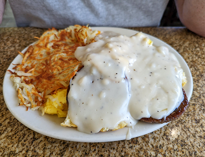 Behold the star attraction—biscuits and gravy that make other breakfast foods jealous. That golden hash brown sidekick isn't too shabby either.