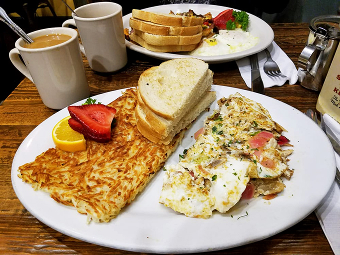 Breakfast nirvana arrives on a white plate: golden hash browns, perfectly executed eggs, and fresh fruit&mdash;the holy trinity of morning bliss.