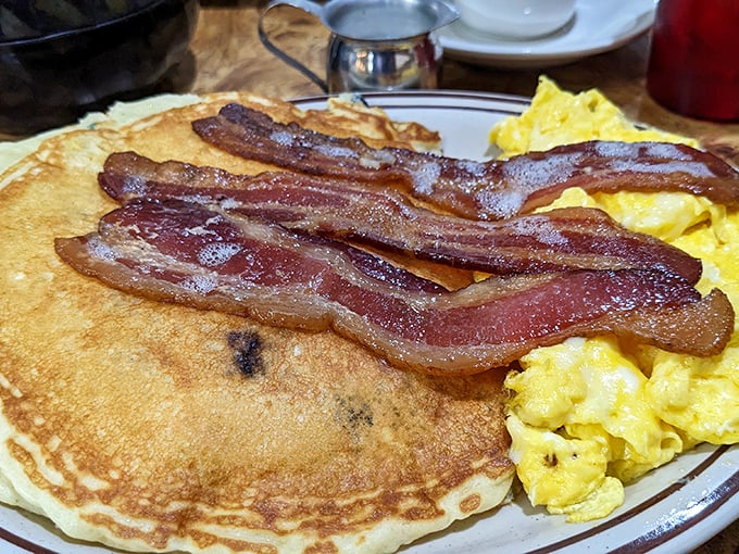 Breakfast perfection on a plate &ndash; golden pancakes with perfectly crisp edges, fluffy scrambled eggs, and bacon cooked to that magical point between chewy and crisp.