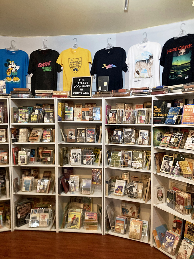 "The Littlest Bookshops in Portland" sign isn't lying—this corner packs literary treasures beneath a lineup of graphic tees that tell their own stories.