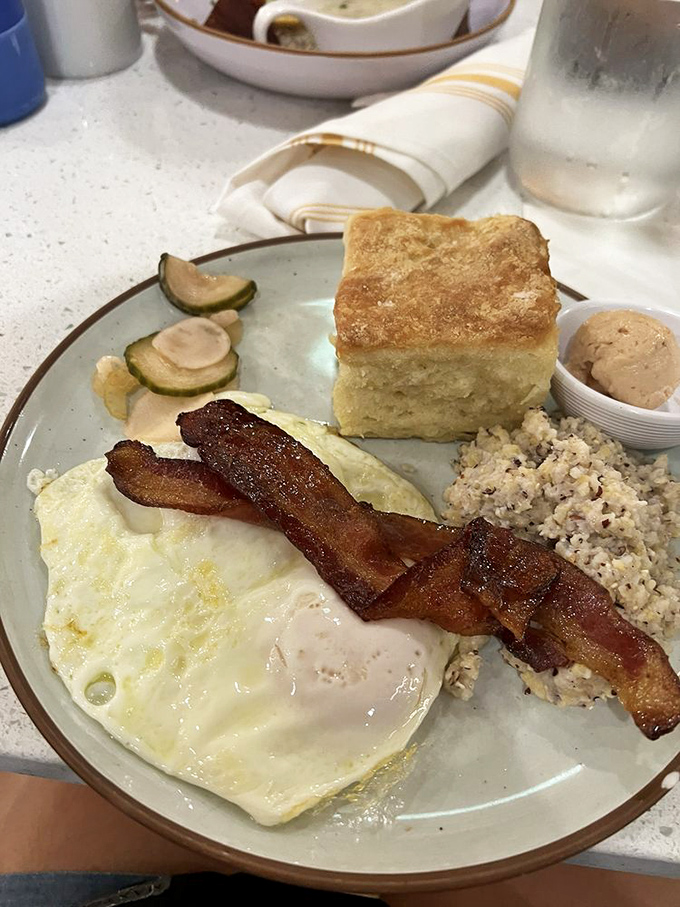 The perfect breakfast trinity: crispy-edged eggs, bacon with the ideal bend-not-break texture, and grits that would make your grandmother nod in approval.