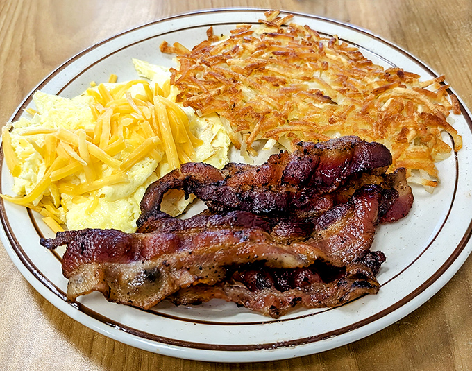 Breakfast perfection on a plate: crispy hashbrowns, fluffy scrambled eggs, and bacon that's achieved that magical crisp-yet-chewy state of nirvana.