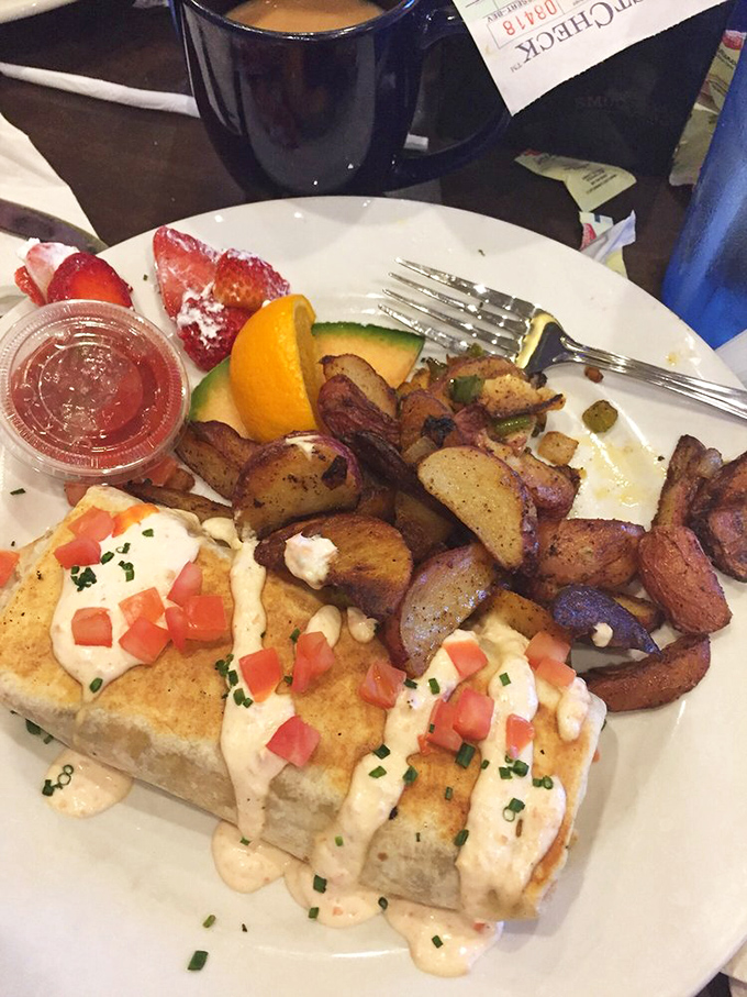 This isn't just breakfast&mdash;it's edible architecture. Creamy sauce, diced tomatoes, and home fries creating a savory skyline worth admiring.