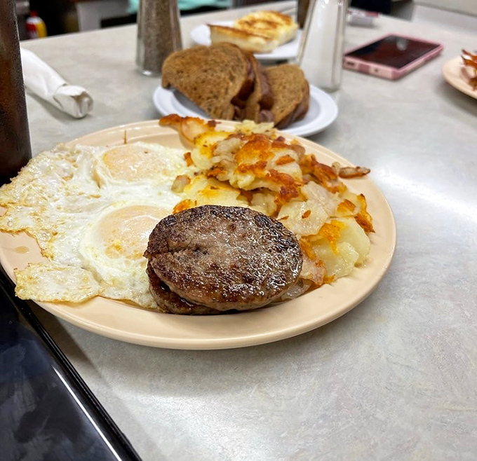 Breakfast perfection on a no-nonsense plate. Sunny-side eggs, golden hash browns, and a hamburger steak that means serious business.