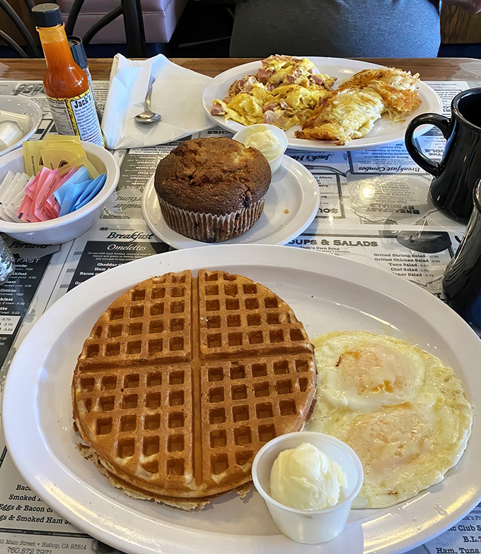 Breakfast nirvana achieved: golden waffles with a perfect grid pattern, eggs with just-right yolks, and a muffin that could make your grandmother jealous.
