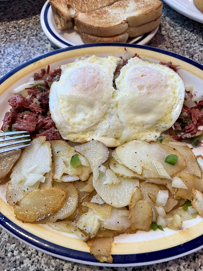 Corned beef hash crowned with perfectly cooked sunny-side-up eggs and crispy potatoes &ndash; breakfast architecture that would make Frank Lloyd Wright jealous.