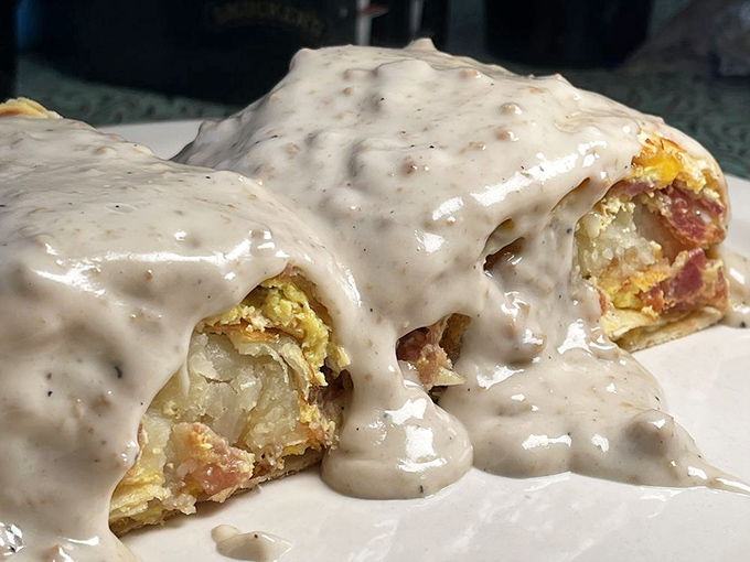 Behold the breakfast burrito in its natural habitat, swimming in country gravy like it's training for the Olympics. Worth setting an alarm for.