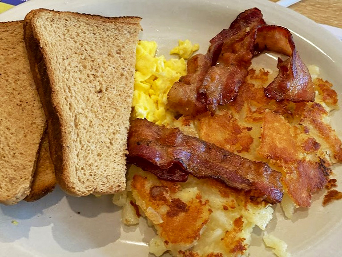 The holy trinity of breakfast: perfectly scrambled eggs, crispy bacon, and golden home fries. Simple perfection on a plate.