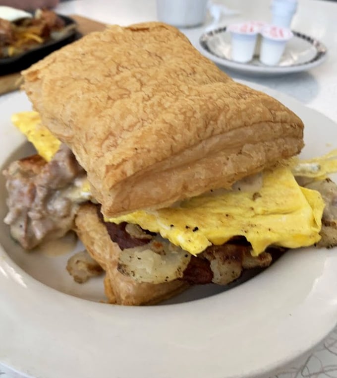 Architecture of perfection—this breakfast sandwich stacks eggs, meat, and potatoes between pastry that would make a French baker weep with joy.