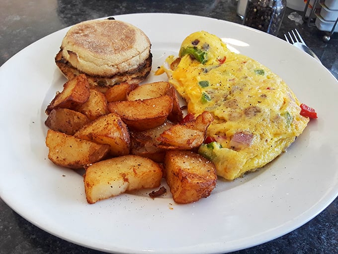 Breakfast nirvana achieved! A perfectly folded omelet alongside golden home fries and an English muffin &ndash; the holy trinity of morning satisfaction.