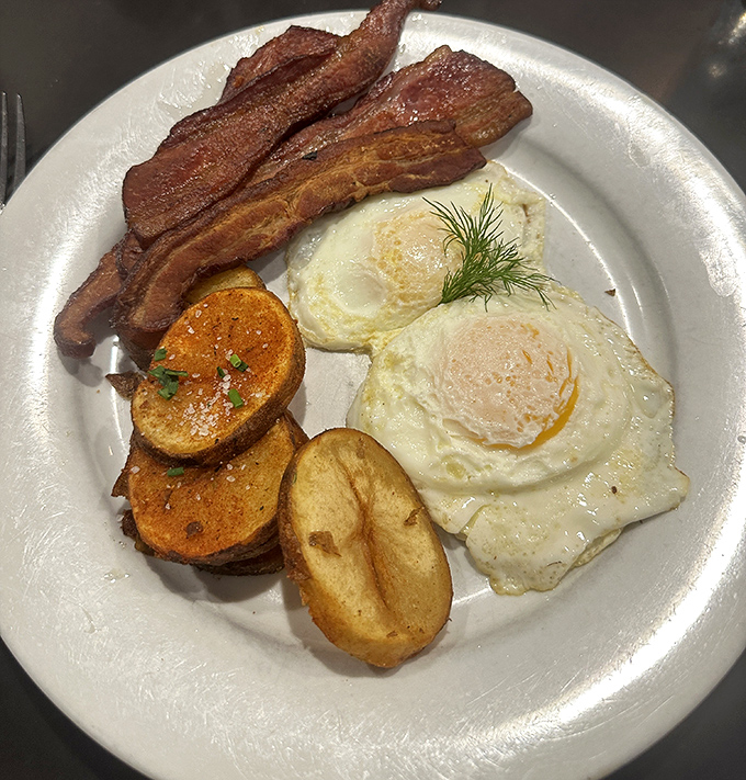 The breakfast trinity &ndash; crispy bacon, golden eggs, and home fries that actually taste like potatoes instead of sad afterthoughts. This is how mornings were meant to begin.