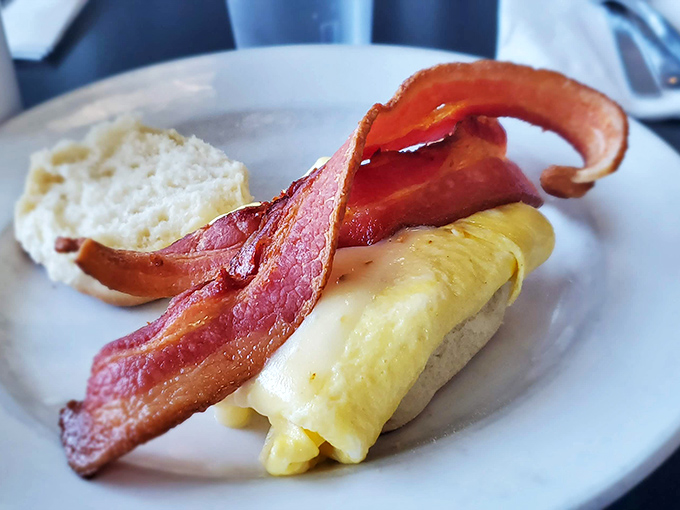 Behold the breakfast sandwich in its natural habitat&mdash;perfectly folded eggs, crispy bacon curled like a smile, waiting to make your morning infinitely better.