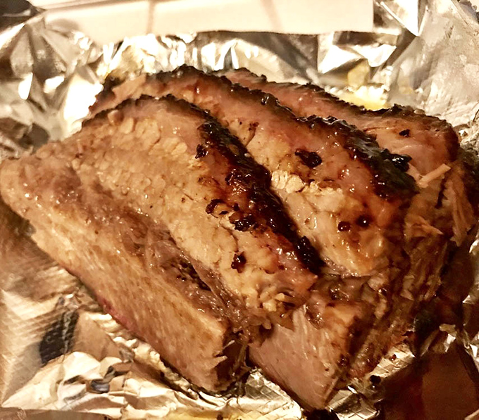 Brisket so tender it practically surrenders to your fork, with a smoke ring that would make Texas pitmasters tip their hats in respect.