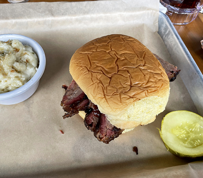 Behold the star attraction: slices of pink-ringed brisket nestled in a pillowy bun, with mac and cheese standing by for moral support.