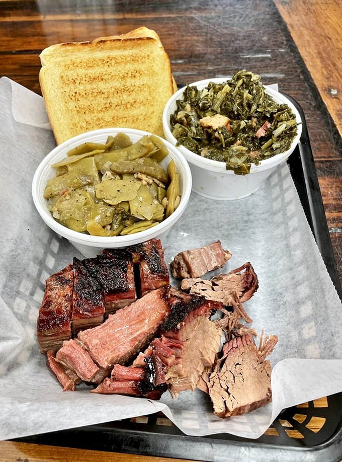 Behold the holy trinity of barbecue perfection: brisket with that telltale smoke ring, collard greens swimming in pot likker, and green beans that didn't come from a can.