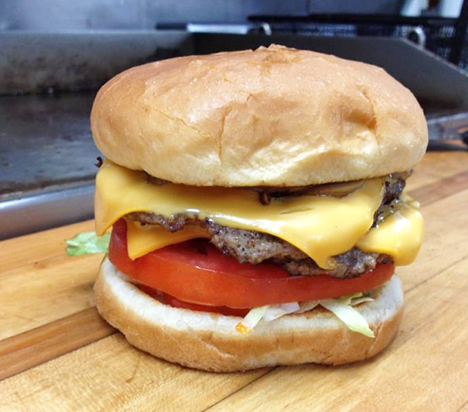 Behold the cheeseburger in its natural habitat &ndash; perfectly melted American cheese cascading over a hand-formed patty with garden-fresh toppings.