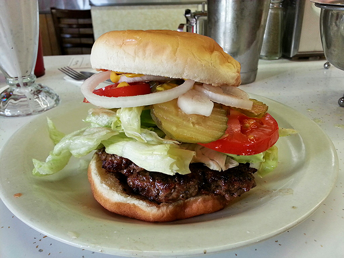 Behold the burger in all its glory! Fresh toppings cascade over a perfectly grilled patty, creating what might be the most honest sandwich in California.