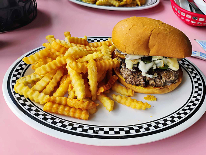 This isn't just a burger; it's a masterpiece of beef perfection on a checkered throne, with crinkle-cut fries standing guard like delicious sentinels.