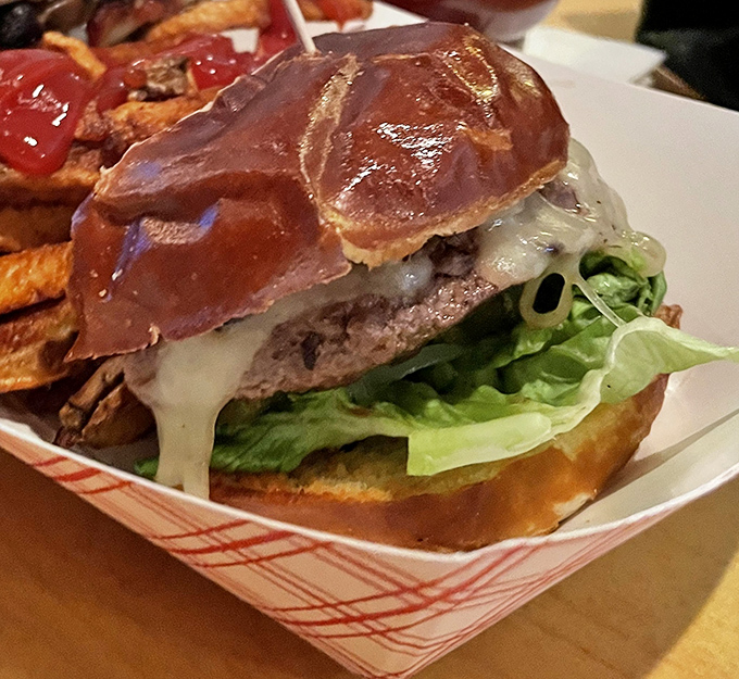 Behold the burger in all its glory&mdash;a perfect marriage of juicy patty, melty cheese, and pretzel bun. This isn't just lunch; it's an event worth clearing your calendar for.