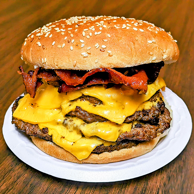 This isn't just a burger; it's a towering monument to excess done right. The cheese cascades like a yellow waterfall of joy.