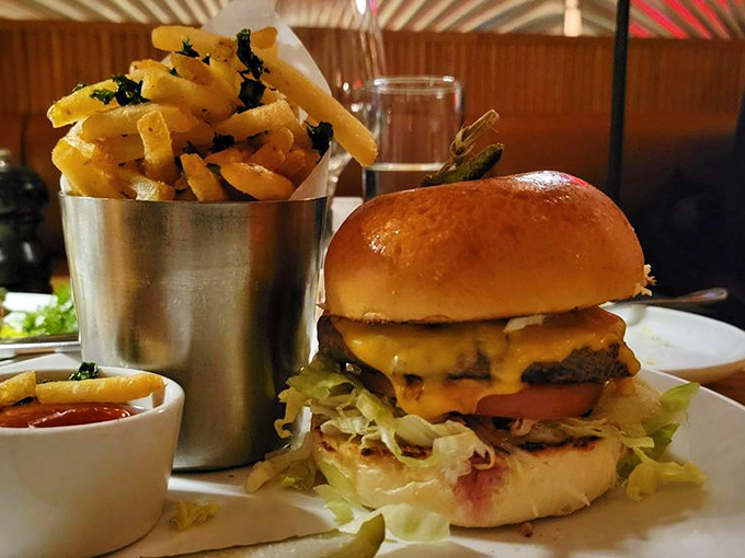 This isn't just a burger—it's architecture. The melted cheese cascades perfectly, while those herb-flecked fries stand at attention.