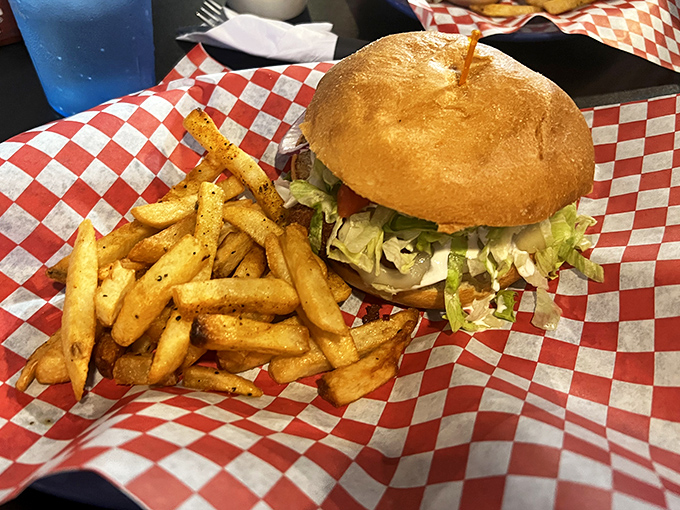 Burger perfection doesn't need fancy frills. This classic creation on a red-checkered basket proves that sometimes simplicity is the ultimate sophistication.