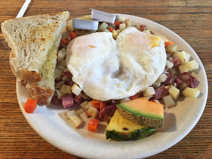 Behold the breakfast of champions: perfectly cooked eggs crowning a colorful kingdom of corned beef hash, with toast standing guard nearby.