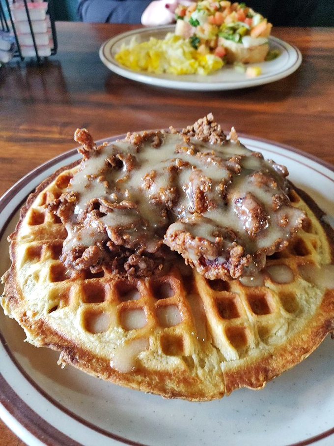 Behold the crown jewel: golden-brown chicken perched atop a perfect waffle, drizzled with maple cream sauce&mdash;a sweet-savory masterpiece that's worth every mile driven.